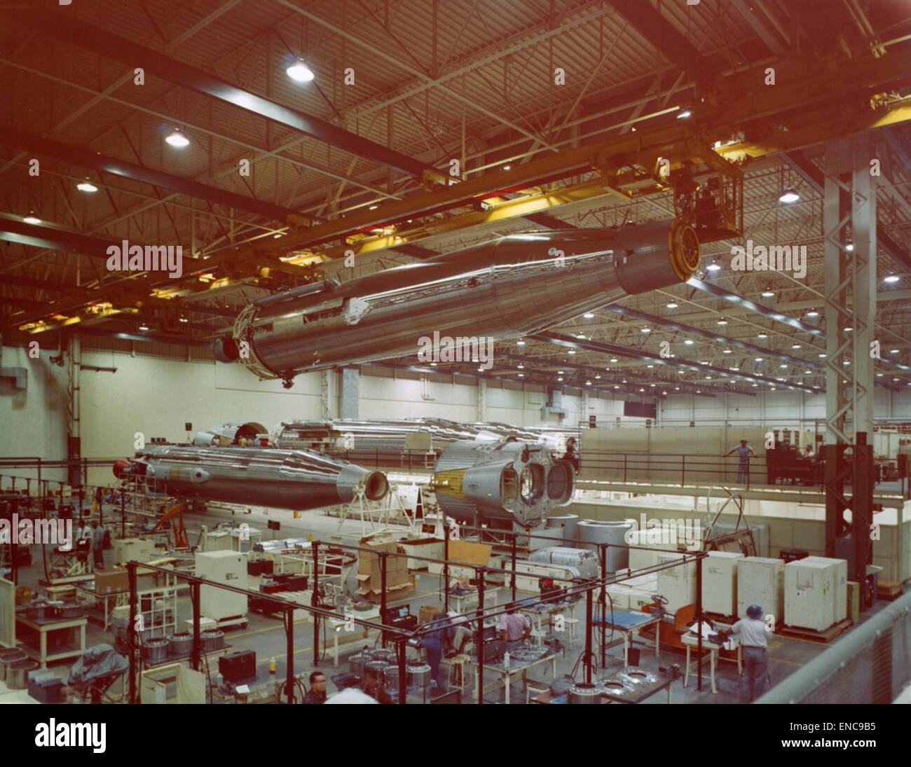 The Atlas rocket is shown on the assembly line with a crane lift ...