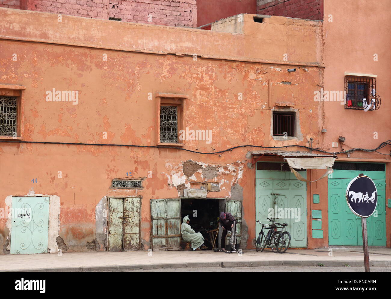 Two Berber men working in a typical red coloured building in Marrakech ...