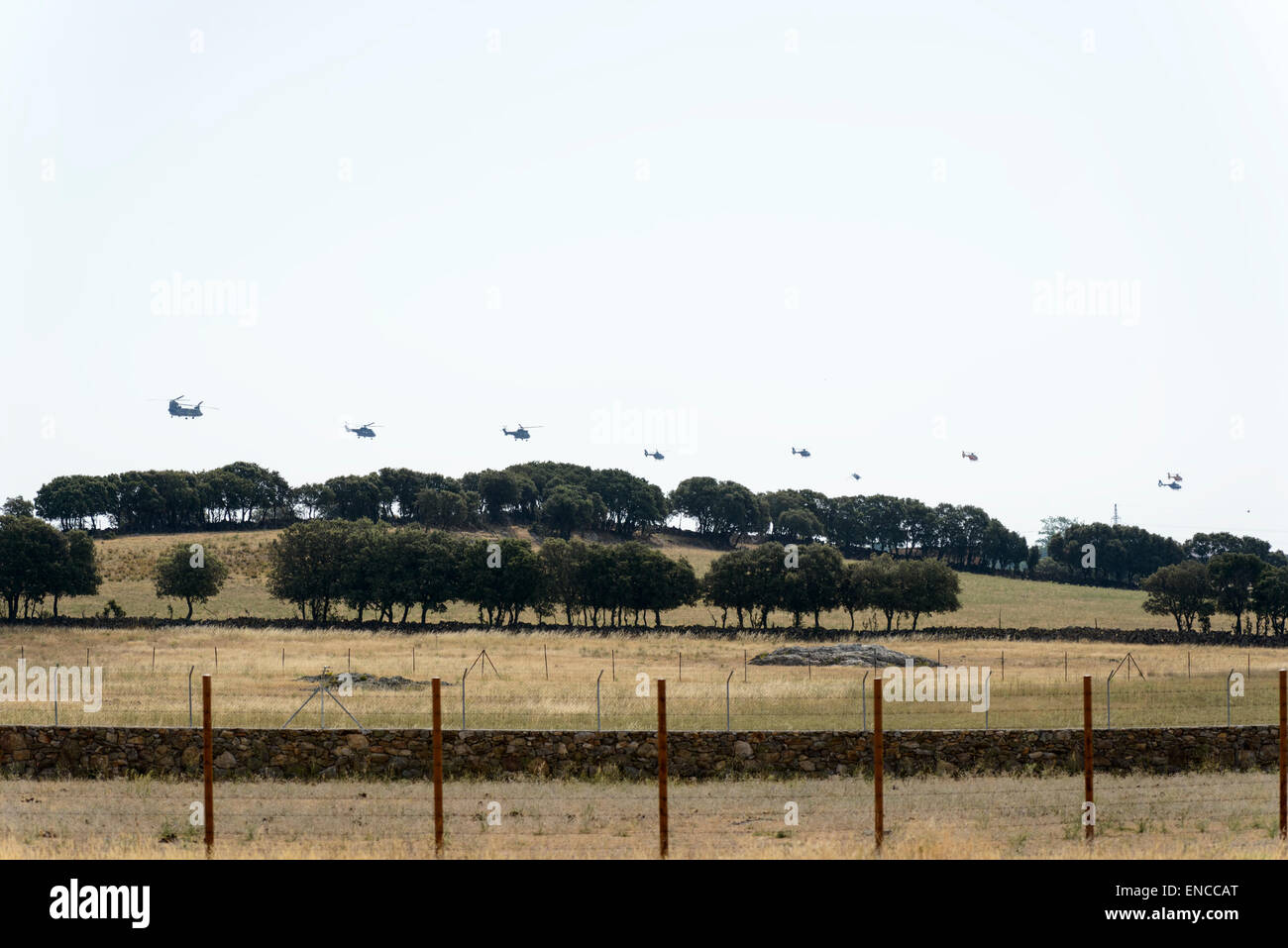 A few Eurocopter Super Puma helicopters flying in line over a farm ...