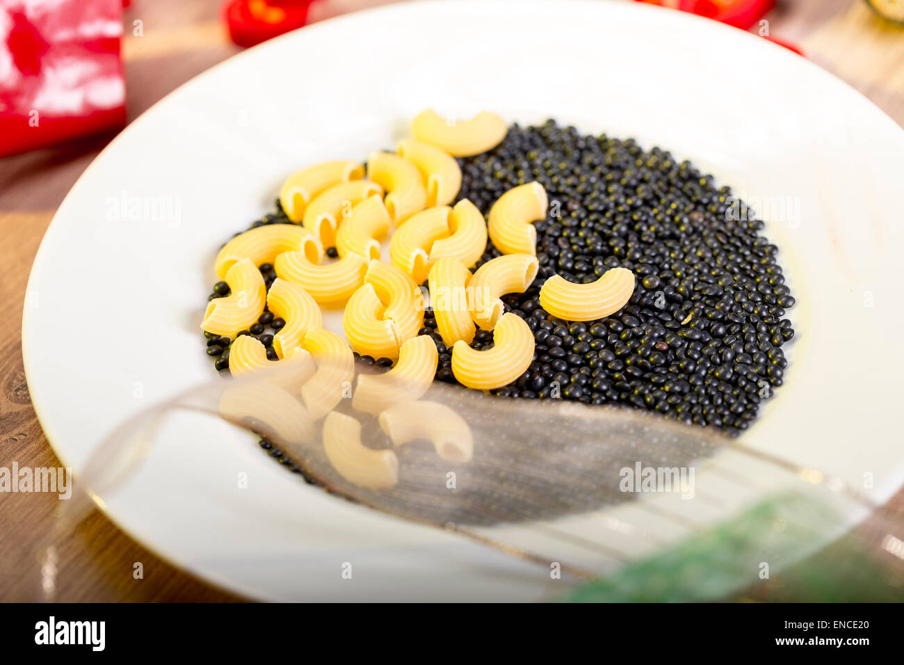 raw pasta and black beluga lentils on a white plate Stock Photo - Alamy