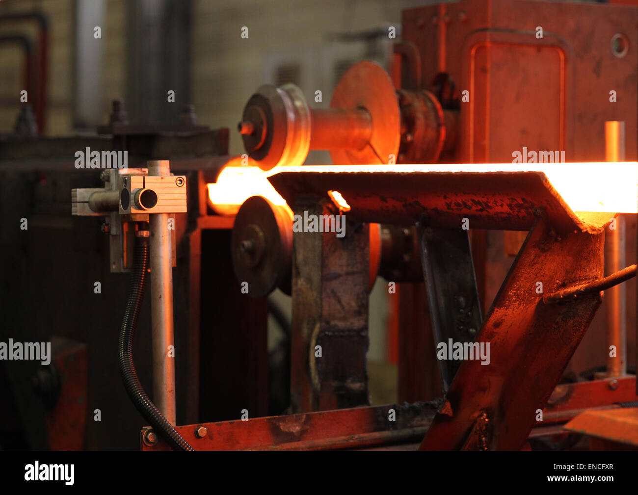 moving the heated metal rod through the rollers in rolling Stock Photo ...