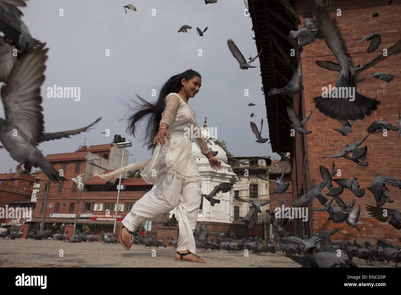 Nepal. 2nd May, 2015. A Nepali girl plays with pigeon at Pashupatinath ...