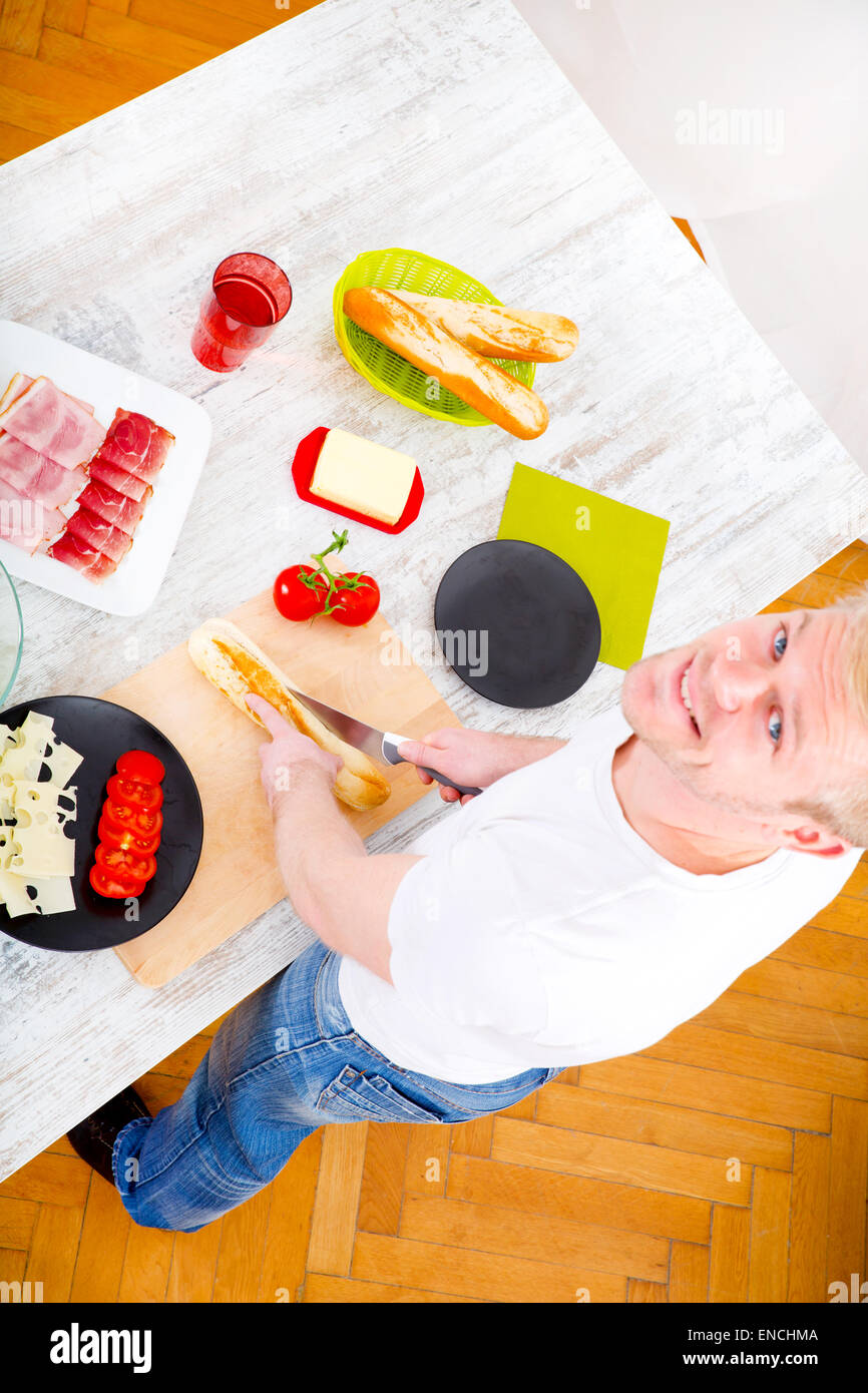 A young man preparing a sandwich in the kitchen Stock Photo - Alamy