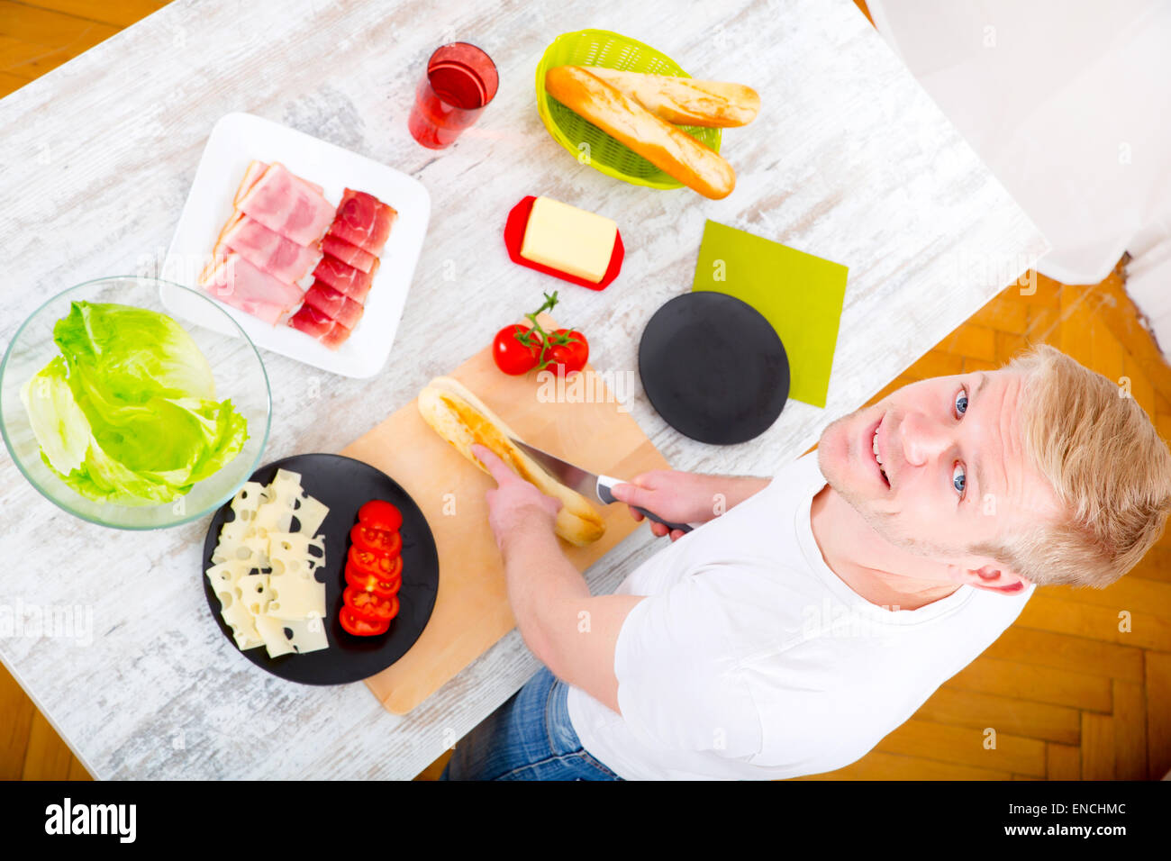 A young man preparing a sandwich in the kitchen Stock Photo - Alamy