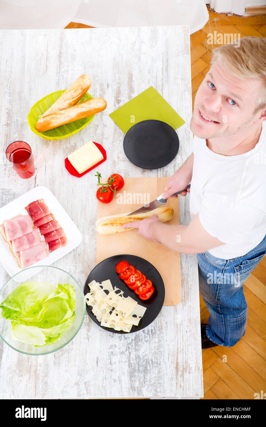 A young man preparing a sandwich in the kitchen Stock Photo - Alamy