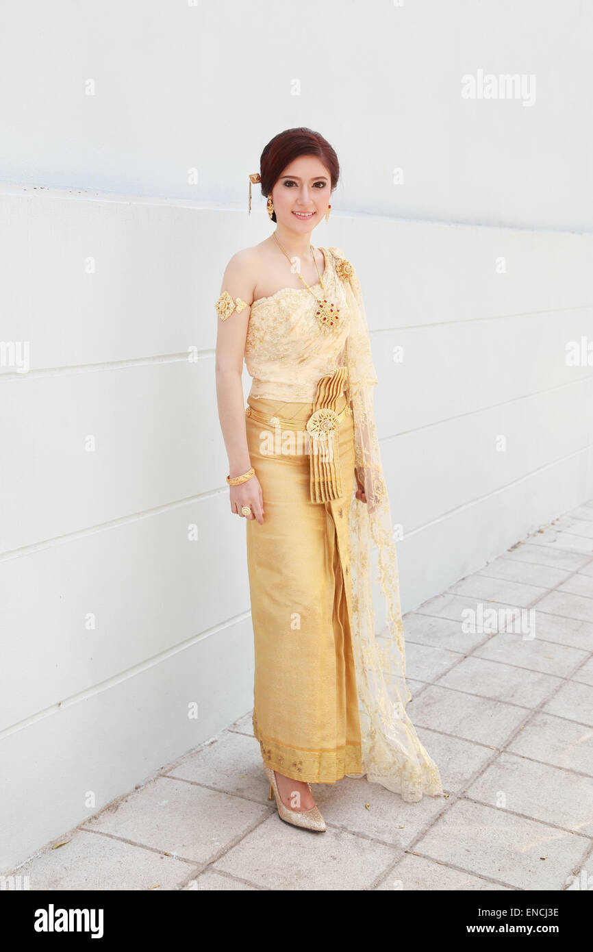 woman with Thai dress and wall background Stock Photo - Alamy