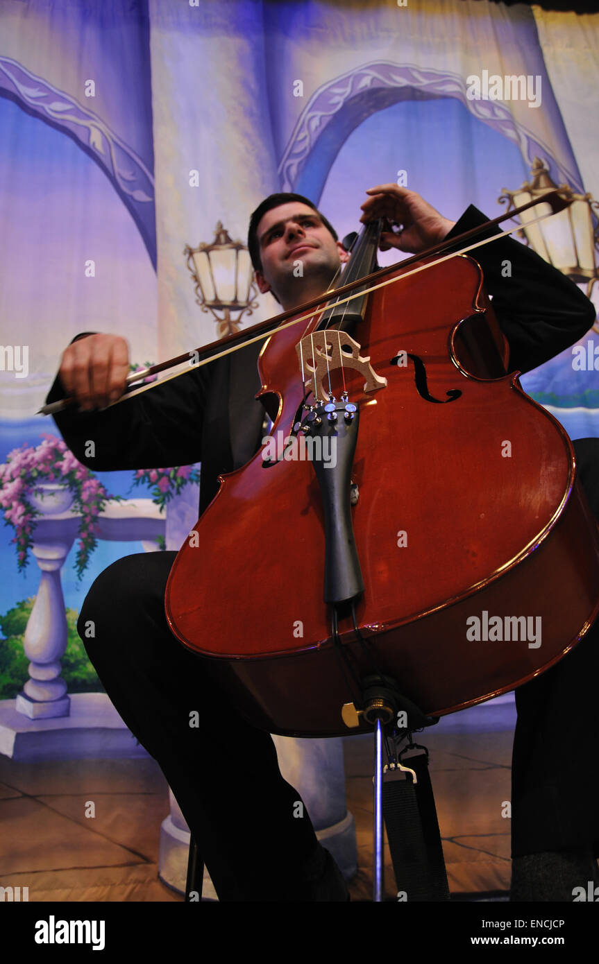 Mature man in formal dinner costume playing the cello in live stage ...