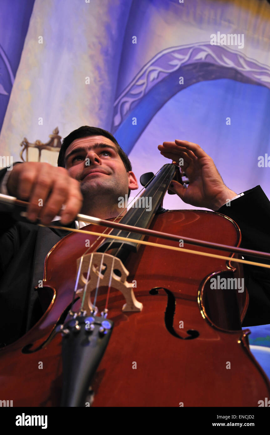 Mature man in formal dinner costume playing the cello in live stage ...