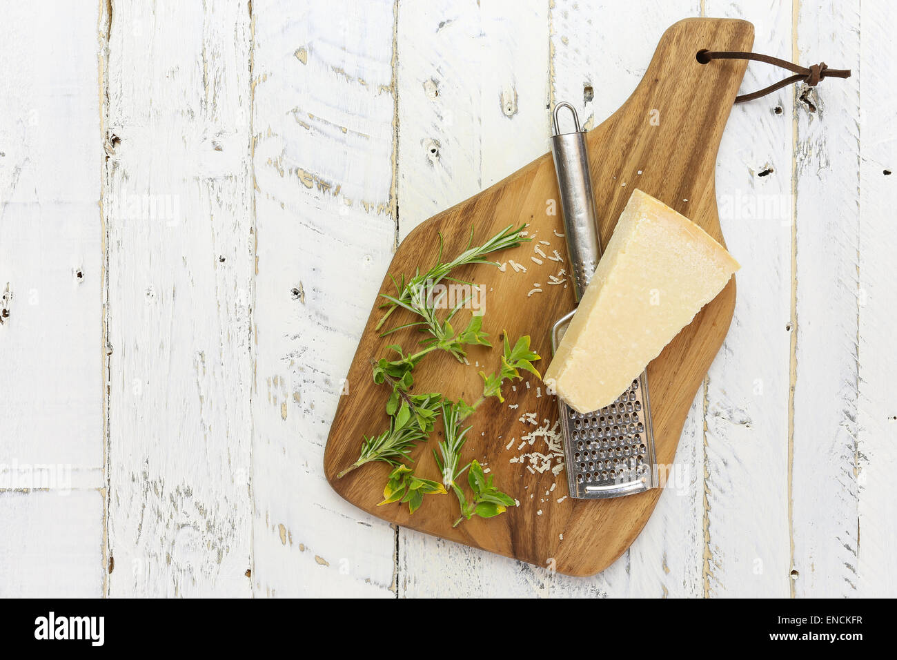 Parmesan chess with grater with fresh italian herbs on chopping board ...