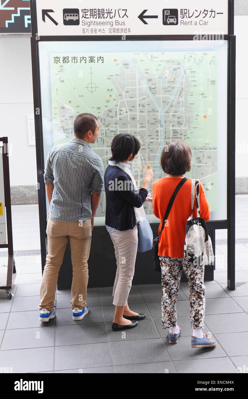 Asian people looking at the city map, bus information & schedule board ...