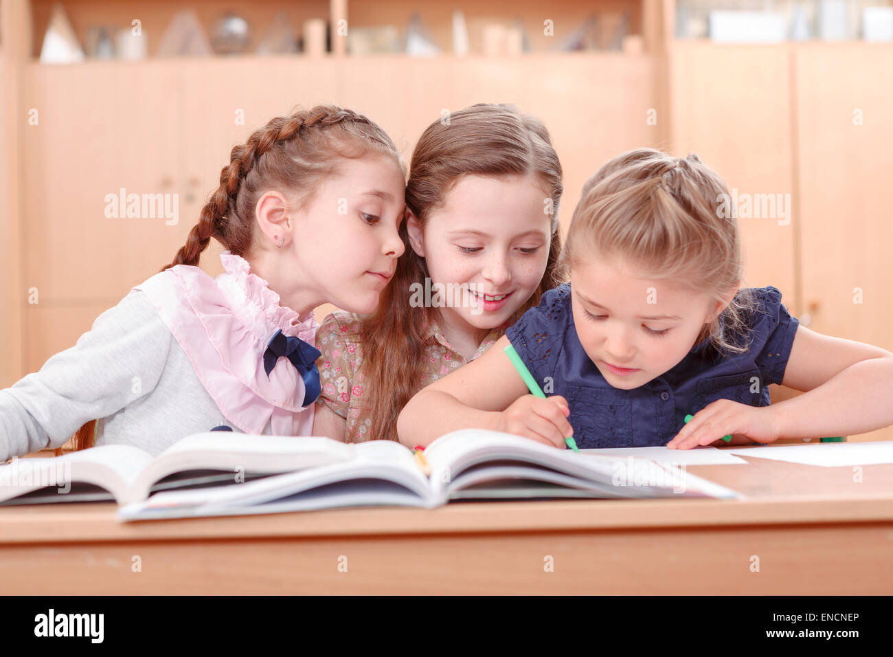 Girls with opened books in classroom Stock Photo - Alamy