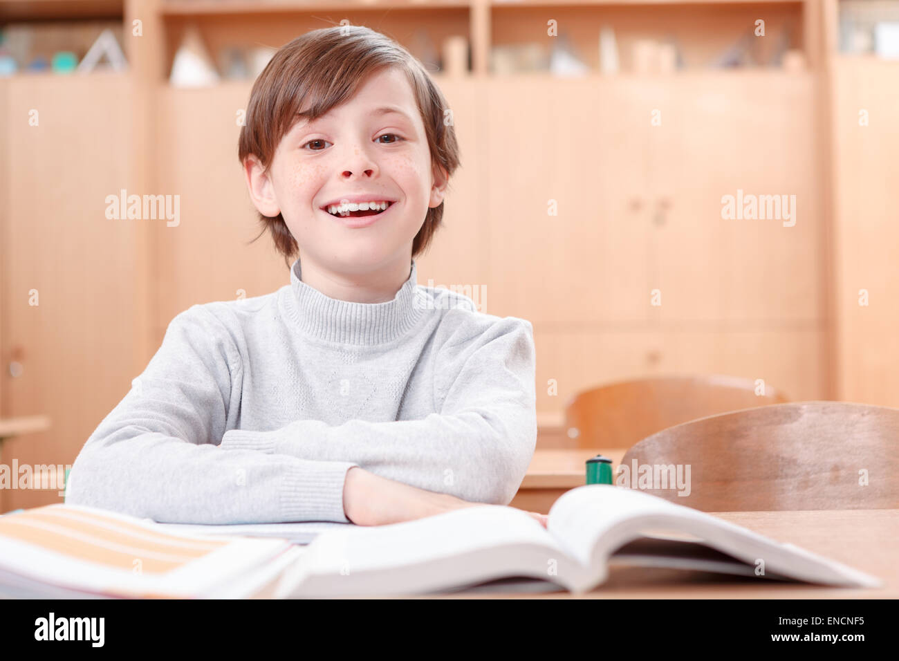 Smiling boy sitting at desk Stock Photo - Alamy