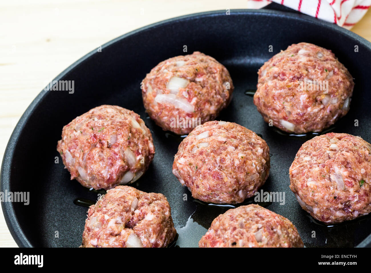 Frying large homemade Italian meatballs on a midium frying pan for ...