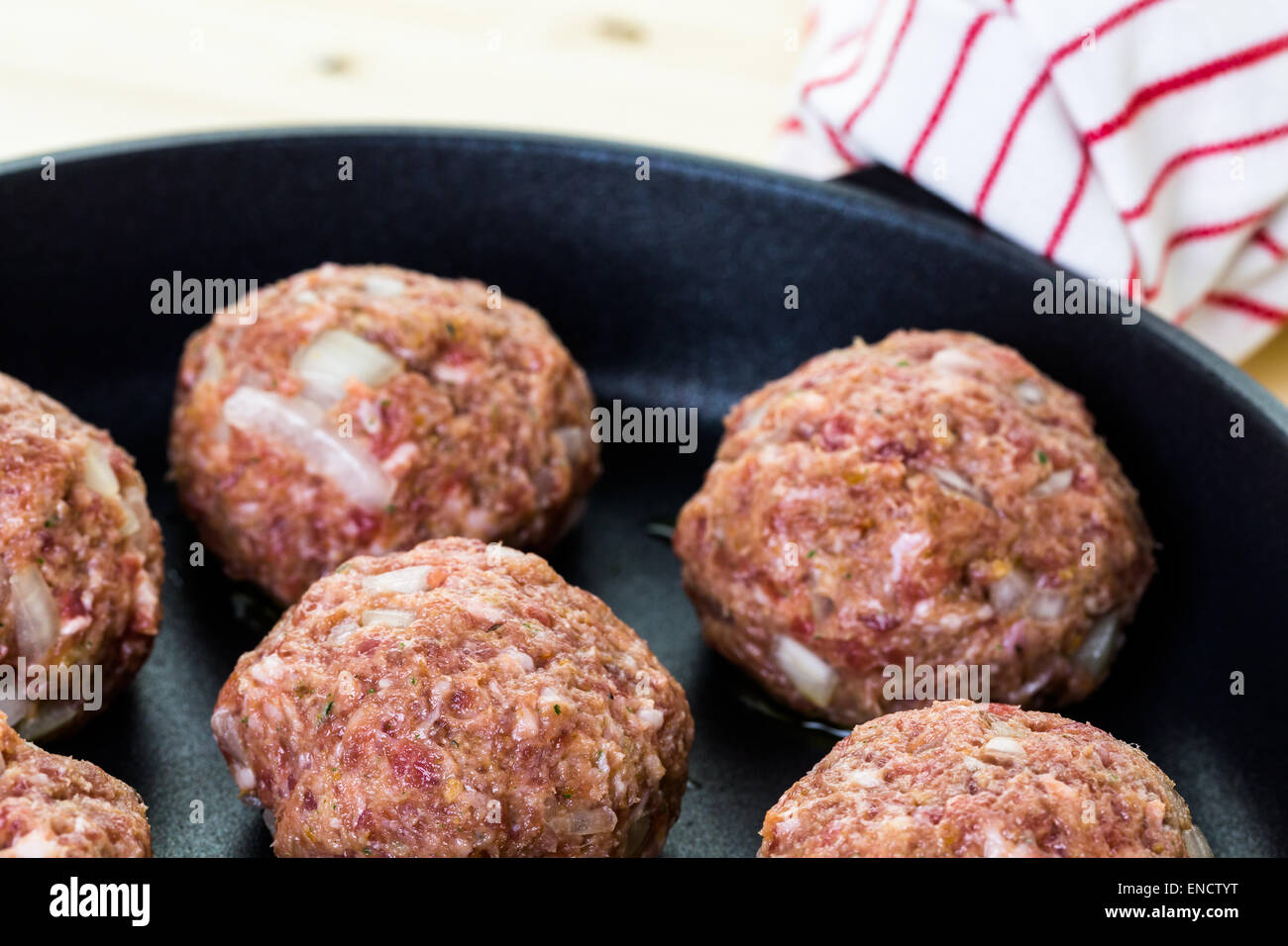 Frying large homemade Italian meatballs on a midium frying pan for ...
