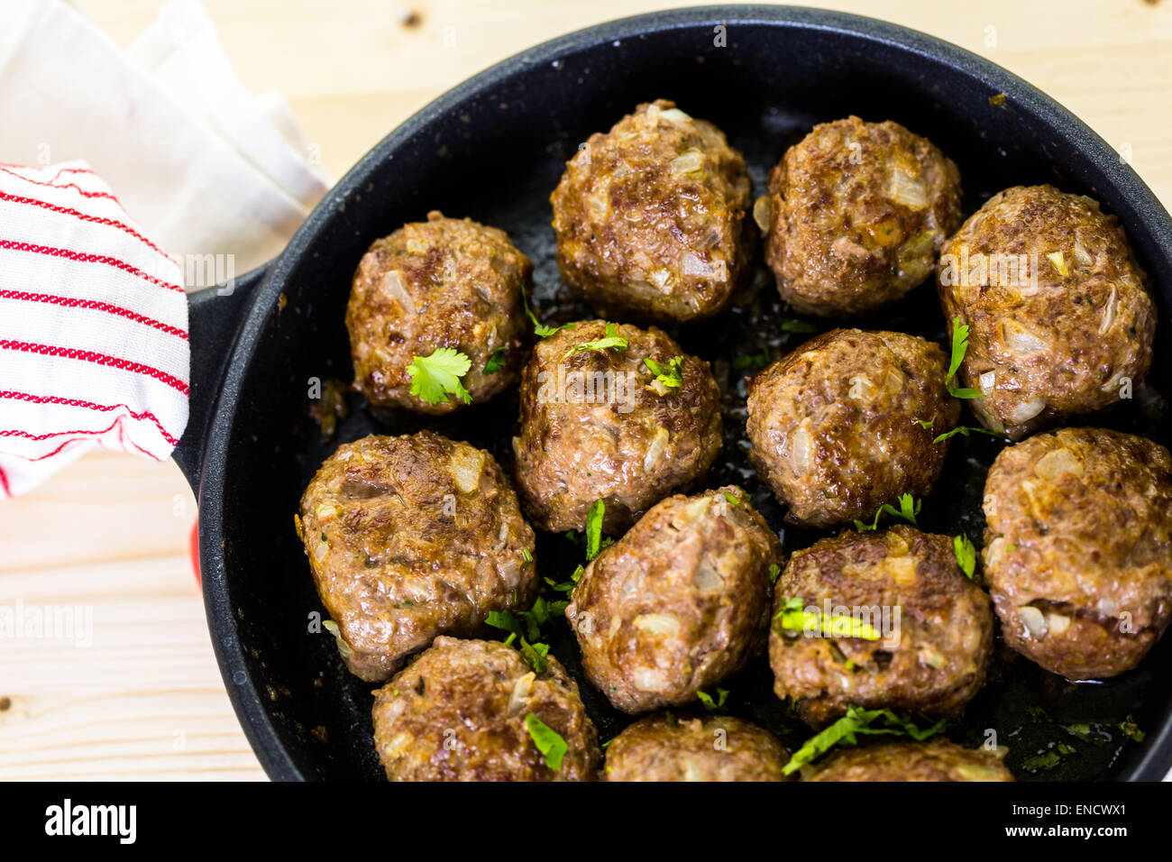 Frying large homemade Italian meatballs on a midium frying pan for ...