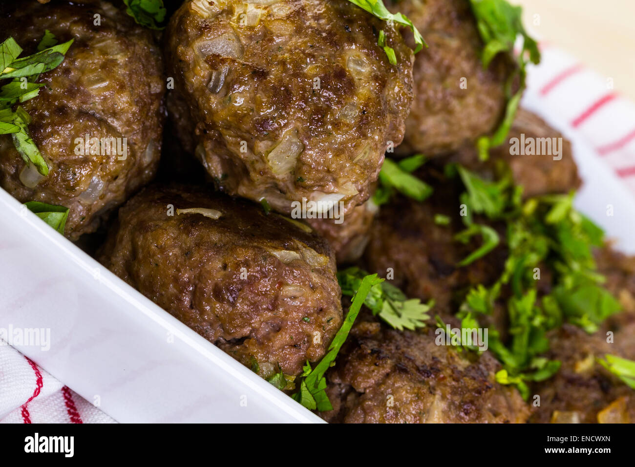 Serving large Italian meatballs in a white serving dish for dinner ...