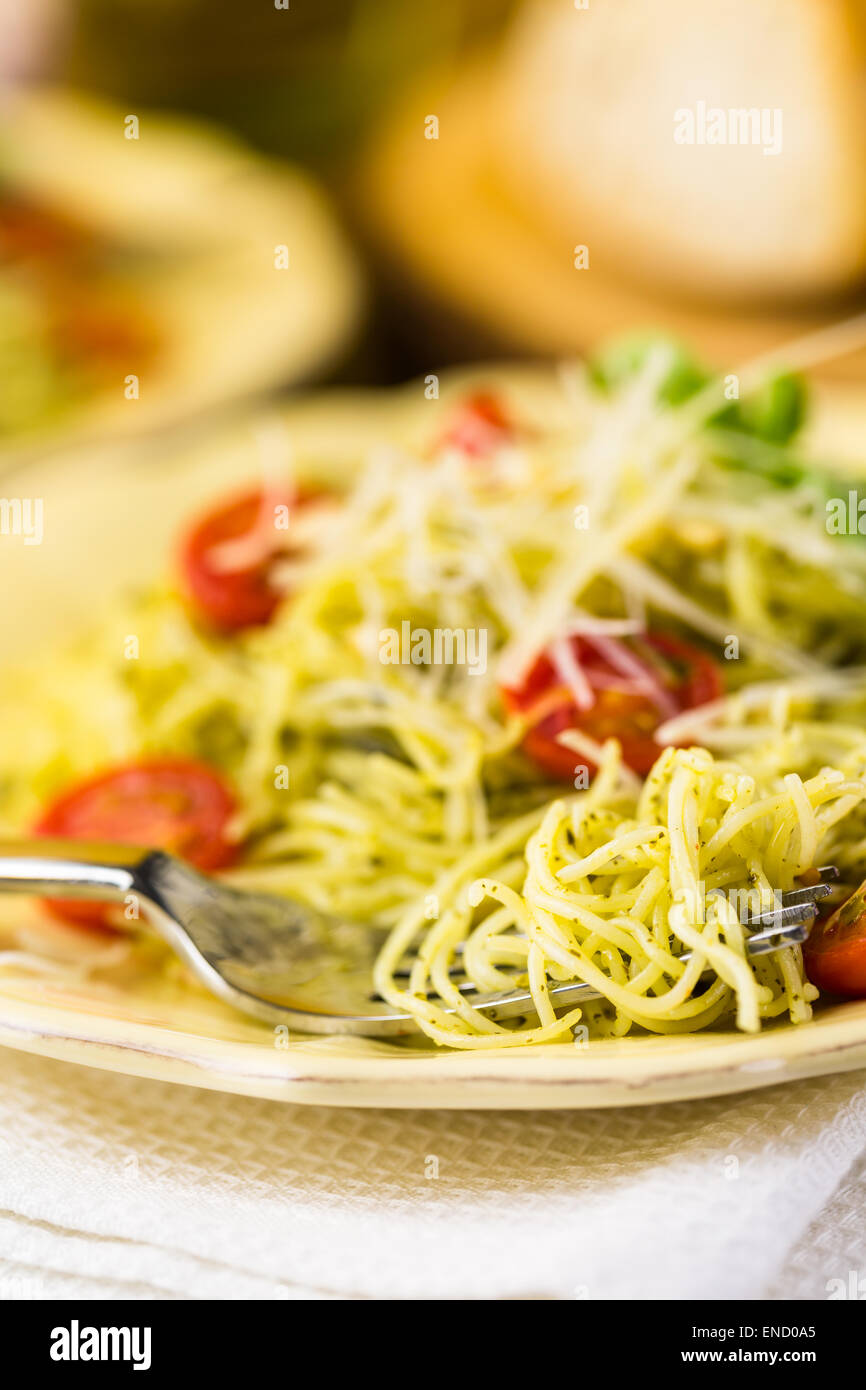 Homemade angel hair pasta with pesto sauce and roasted cherry tomatoes ...