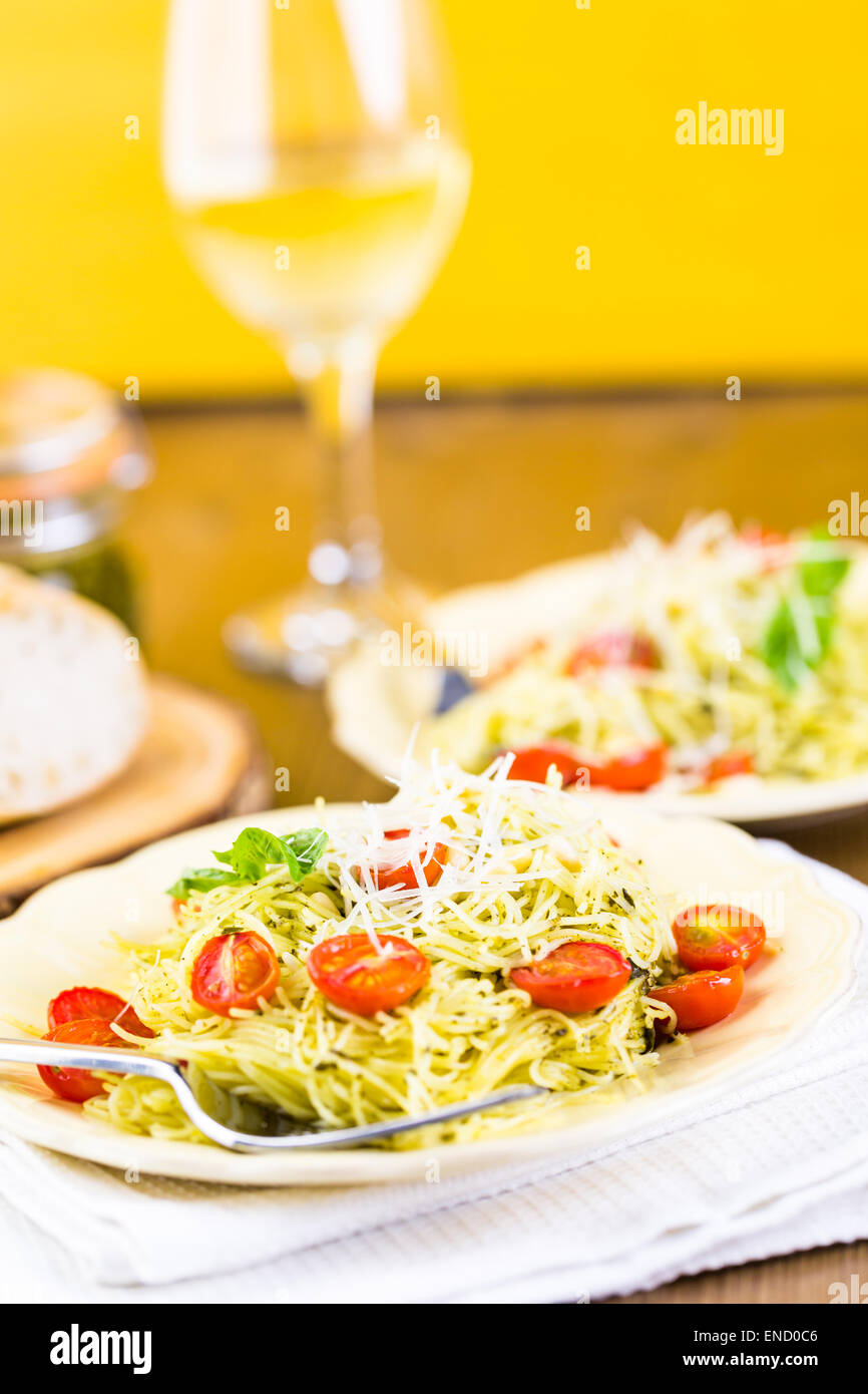 Homemade angel hair pasta with pesto sauce and roasted cherry tomatoes ...