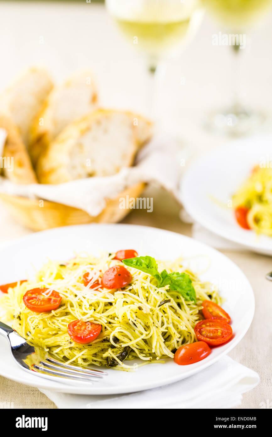 Homemade angel hair pasta with pesto sauce and roasted cherry tomatoes ...
