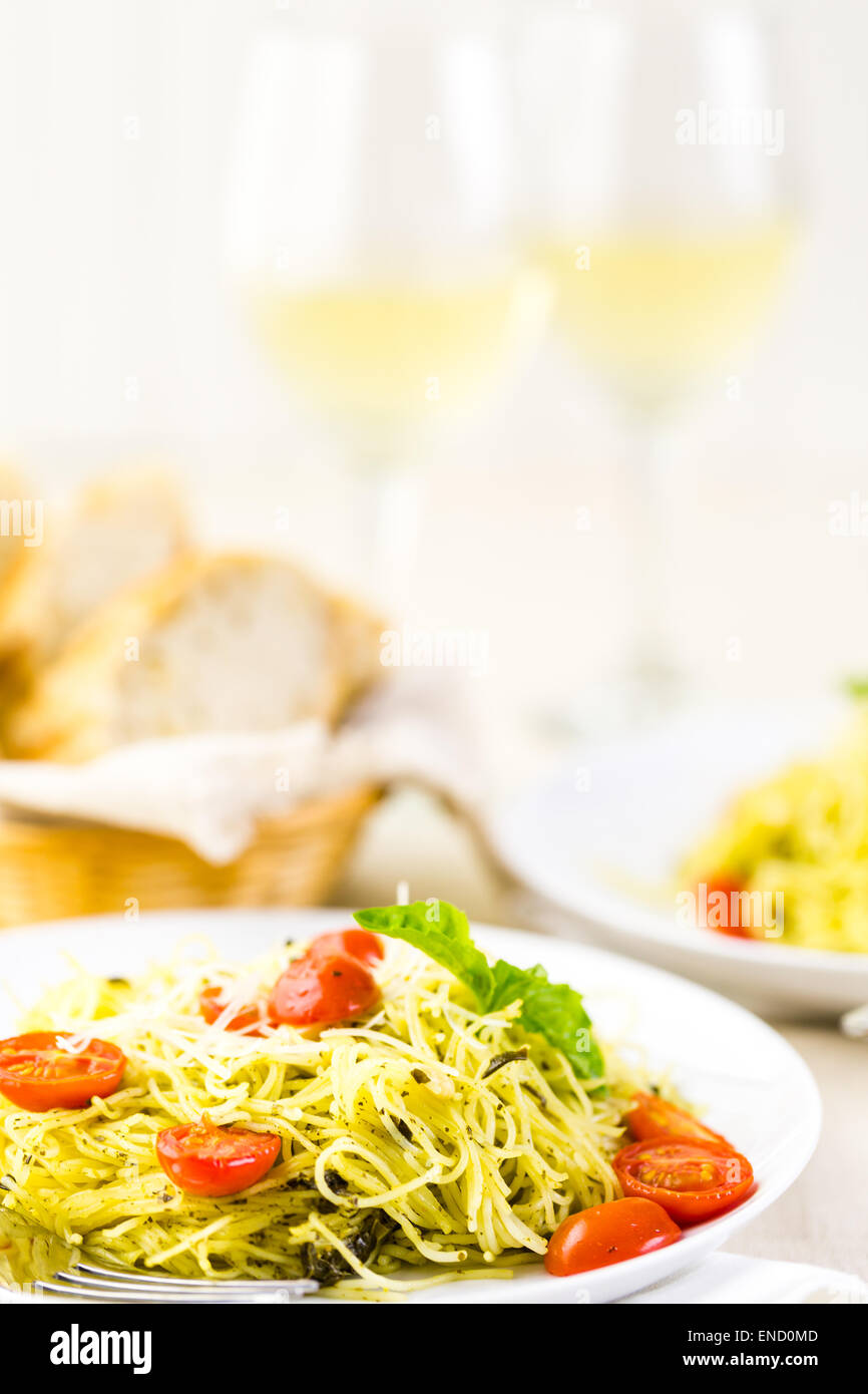 Homemade angel hair pasta with pesto sauce and roasted cherry tomatoes ...