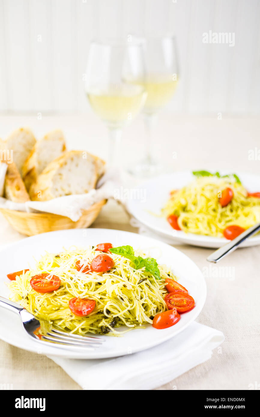Homemade angel hair pasta with pesto sauce and roasted cherry tomatoes ...