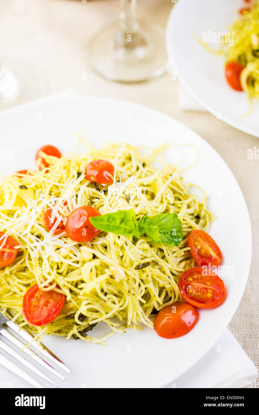 Homemade angel hair pasta with pesto sauce and roasted cherry tomatoes ...