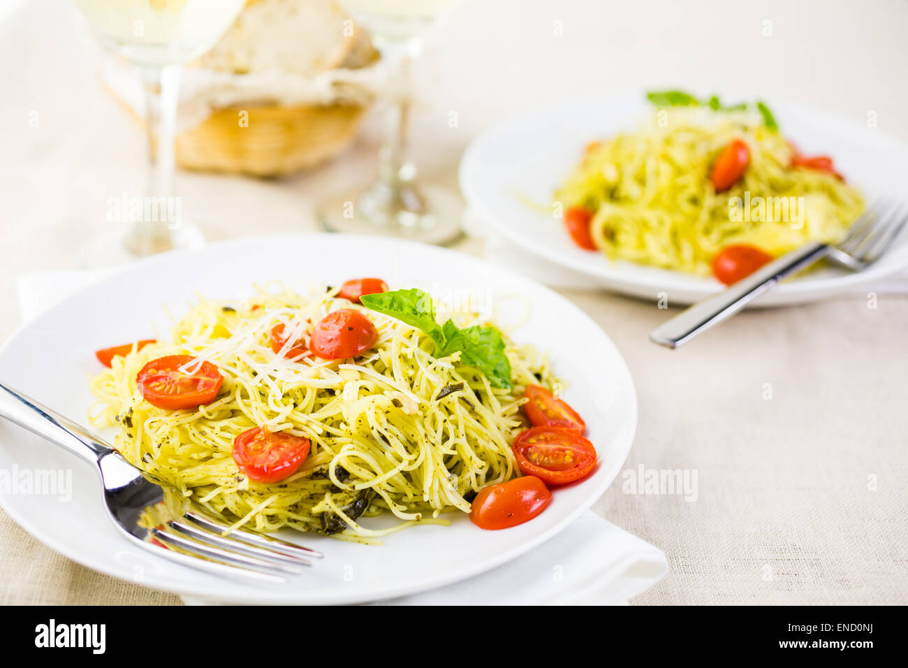Homemade angel hair pasta with pesto sauce and roasted cherry tomatoes ...