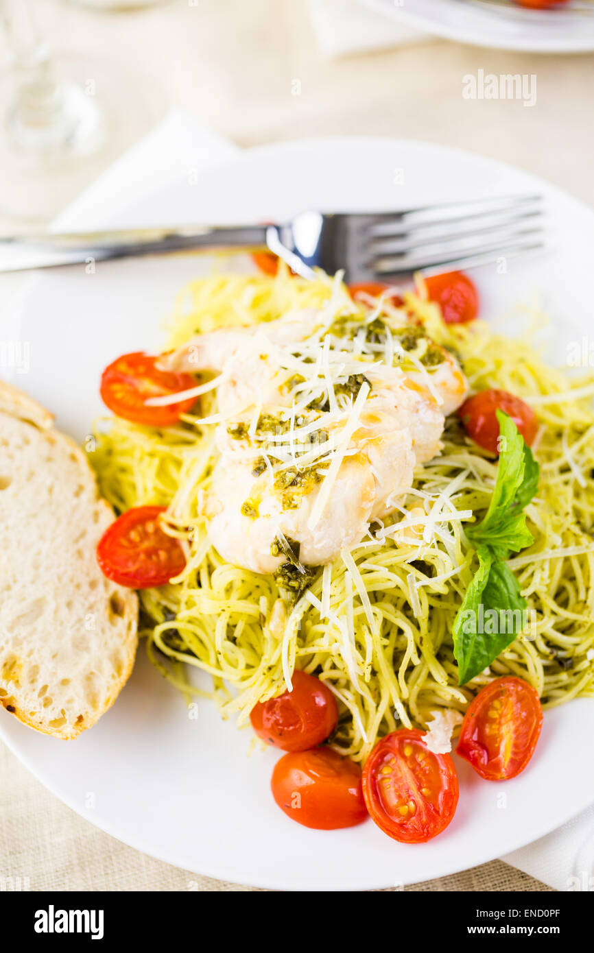 Homemade angel hair pasta with pesto sauce, roasted cherry tomatoes and ...