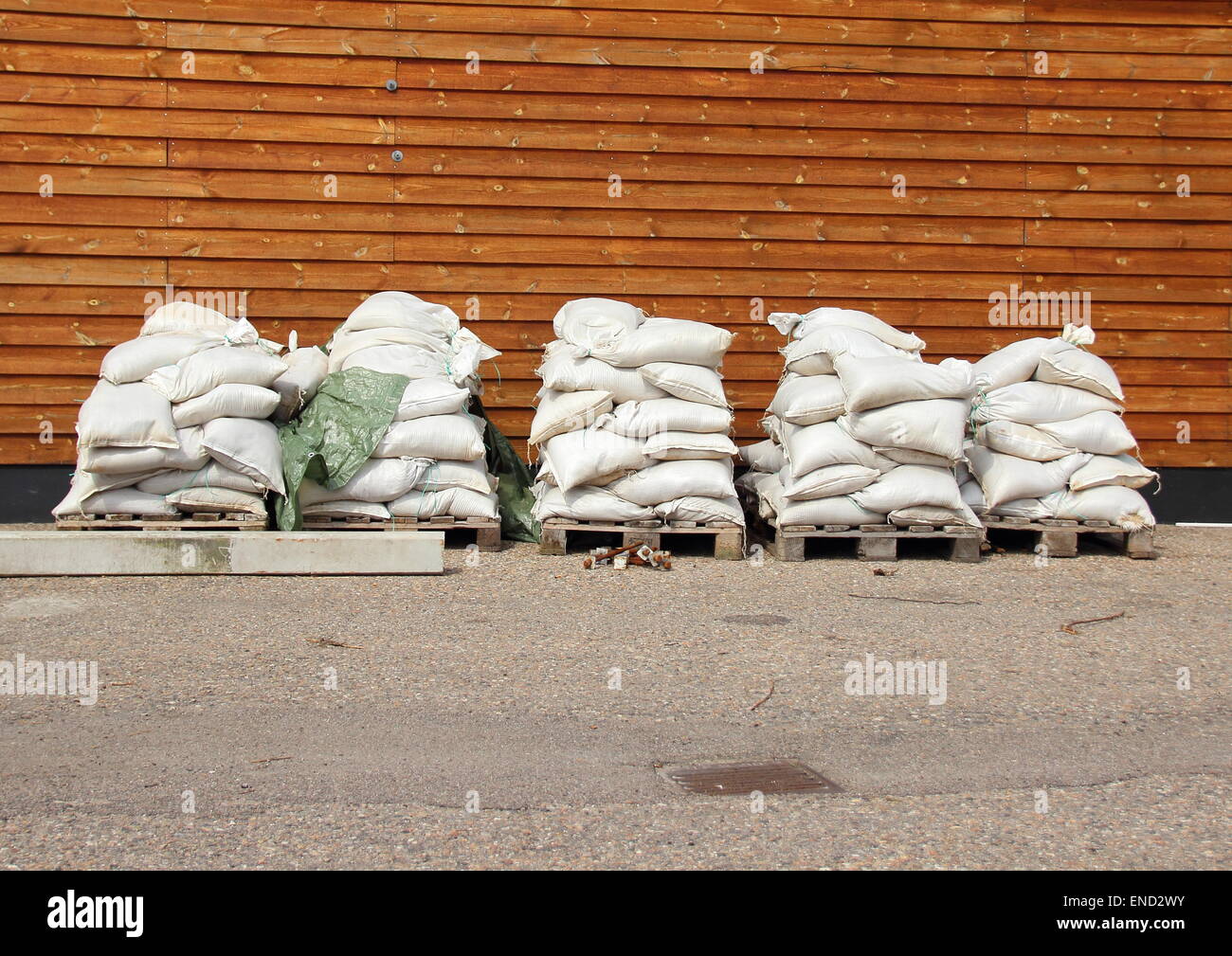 Sandbags in five piles with wooden wall in background Stock Photo - Alamy