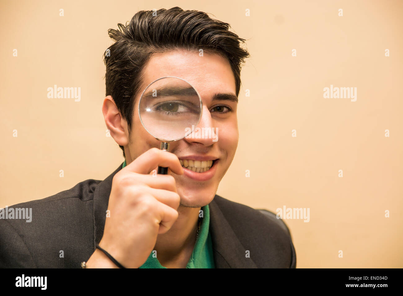 Handsome young man holding a magnifying glass Stock Photo - Alamy