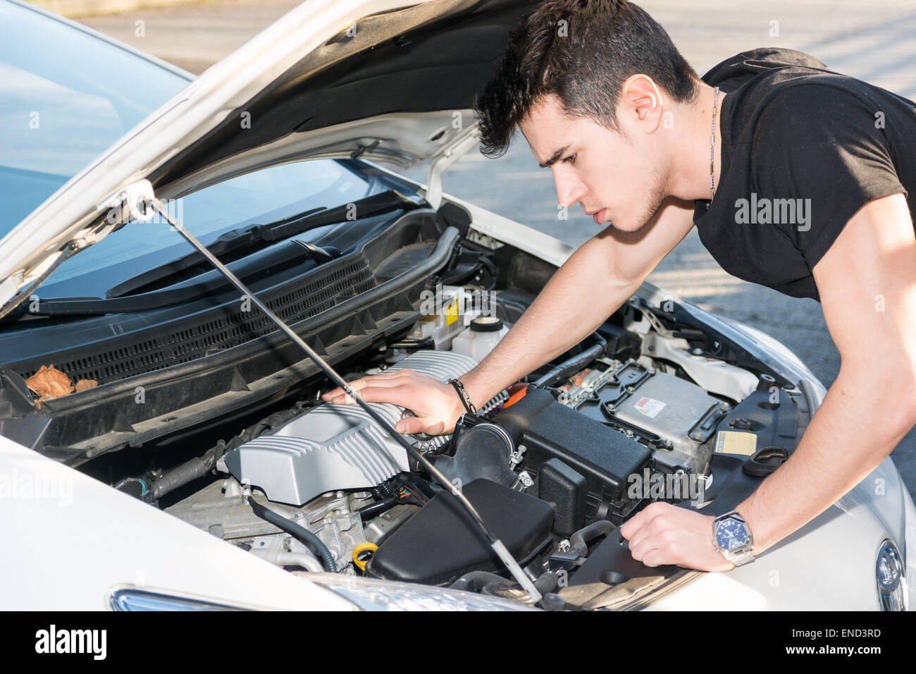 Handsome young man trying to repair a car engine Stock Photo - Alamy