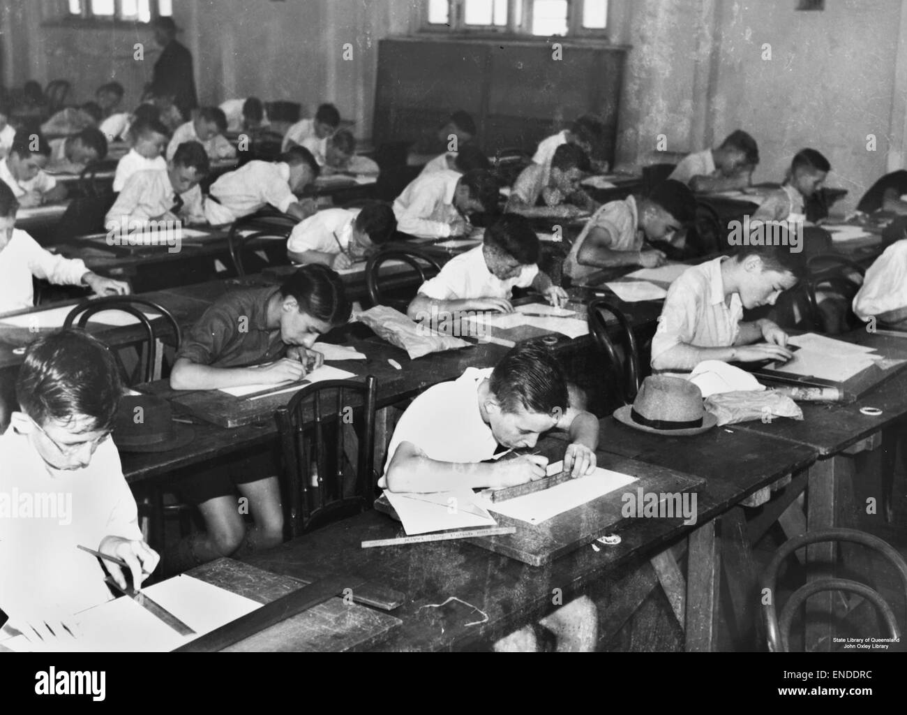 The photograph shows school children taking exams inside a classroom ...