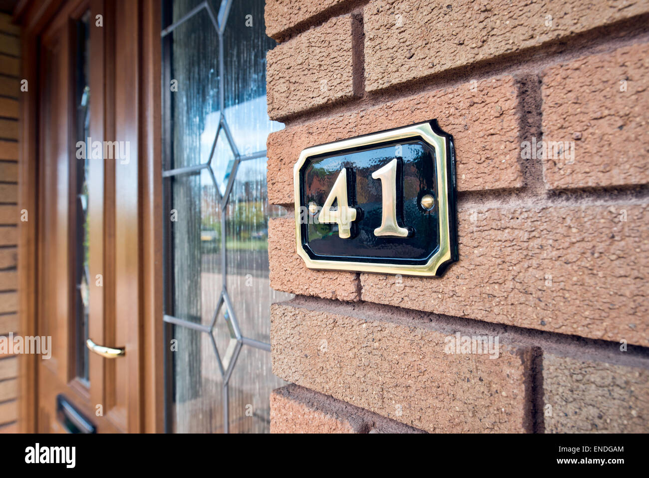 A brass plaque displaying the number 41 on a brick wall by the front ...