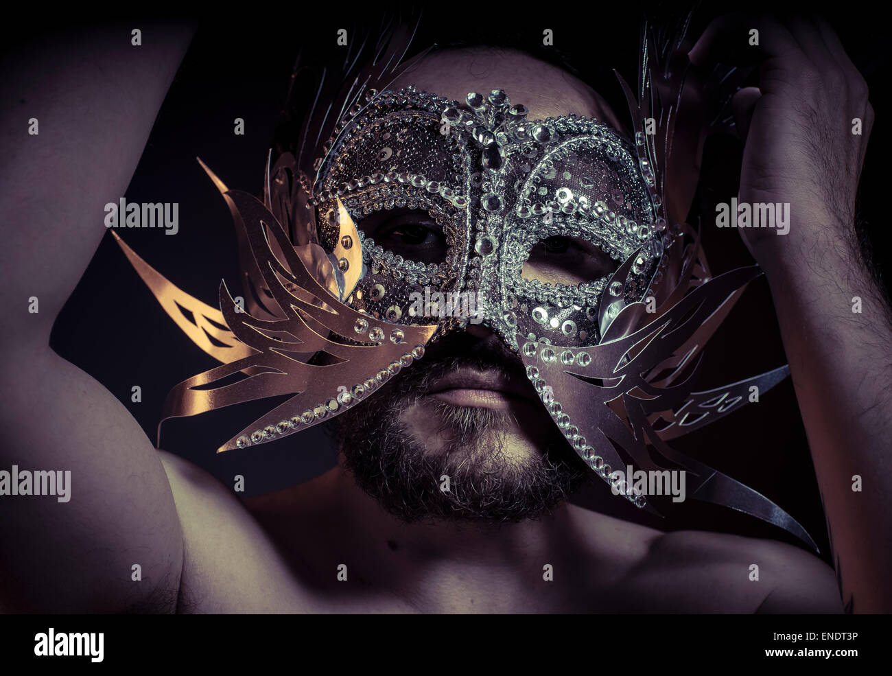 Pose, bearded man with silver mask Venetian style. Mystery and ...