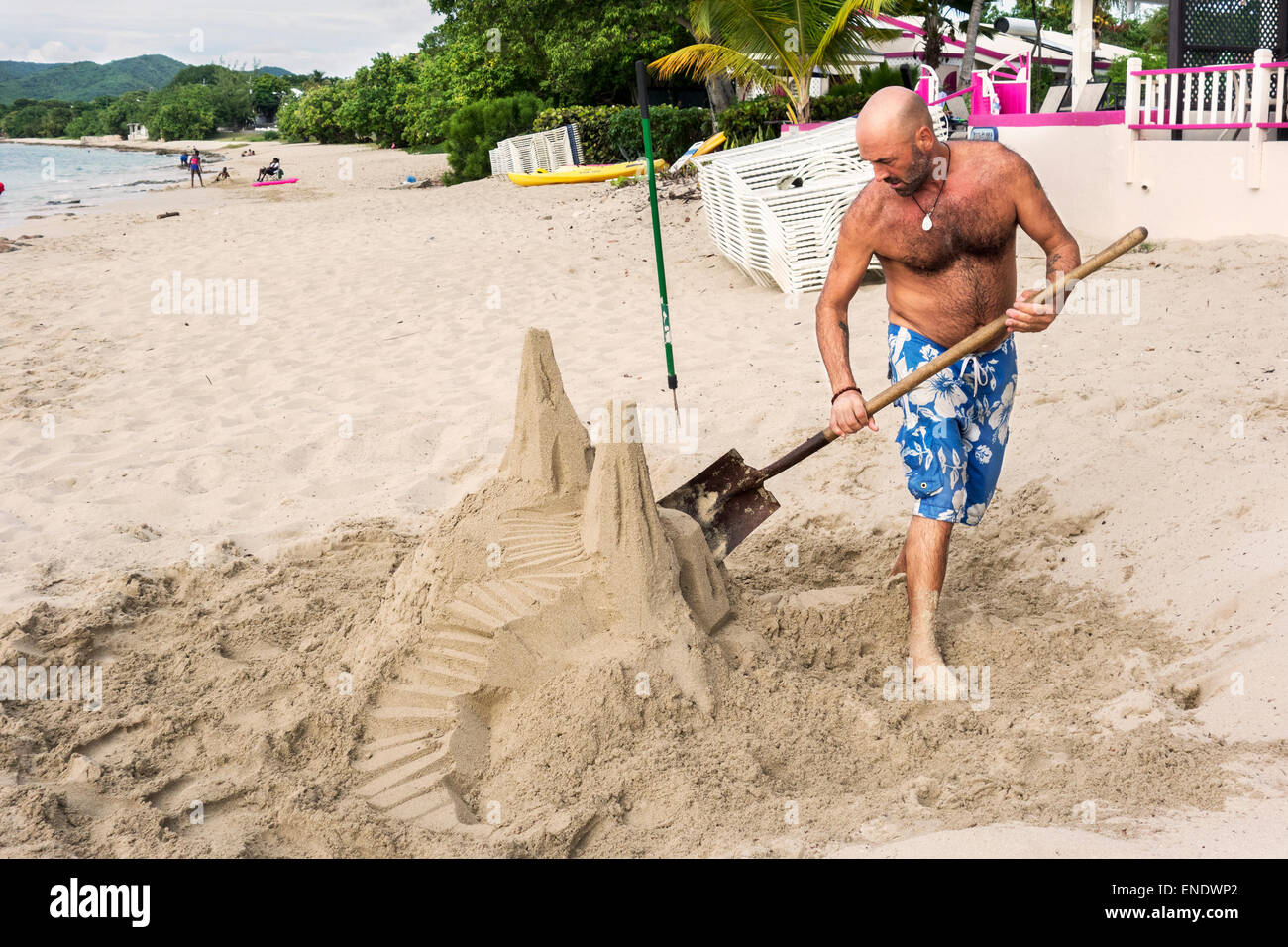 A Caucasian man builds a sand castle on Sandcastle Beach, west end, St ...