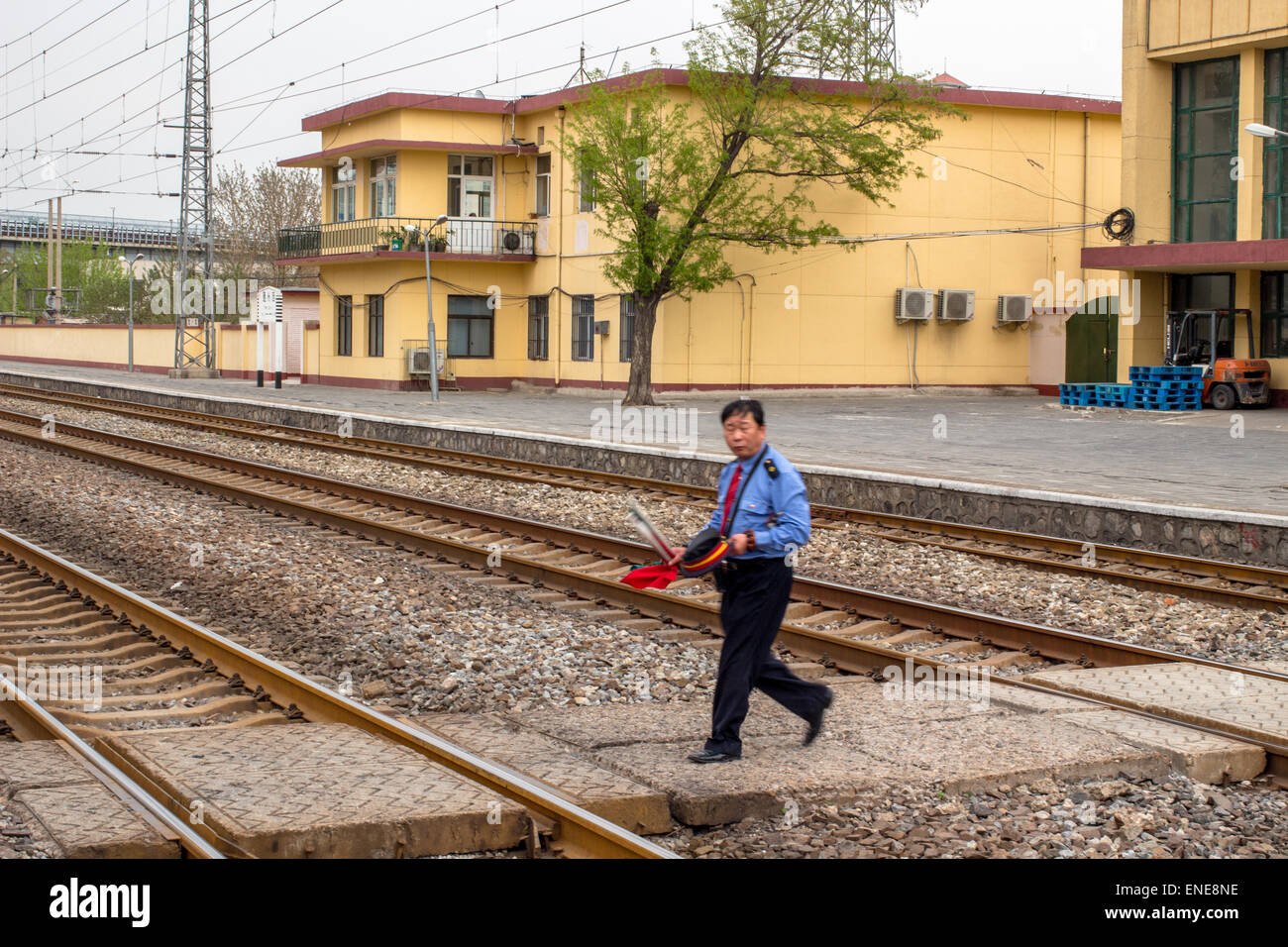A railway staff is walking across the rail track Stock Photo - Alamy
