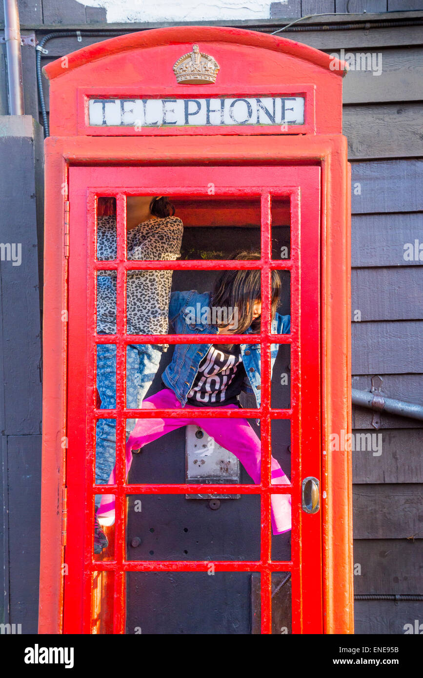 Children playing inside old red British telephone booth kiosk Stock ...