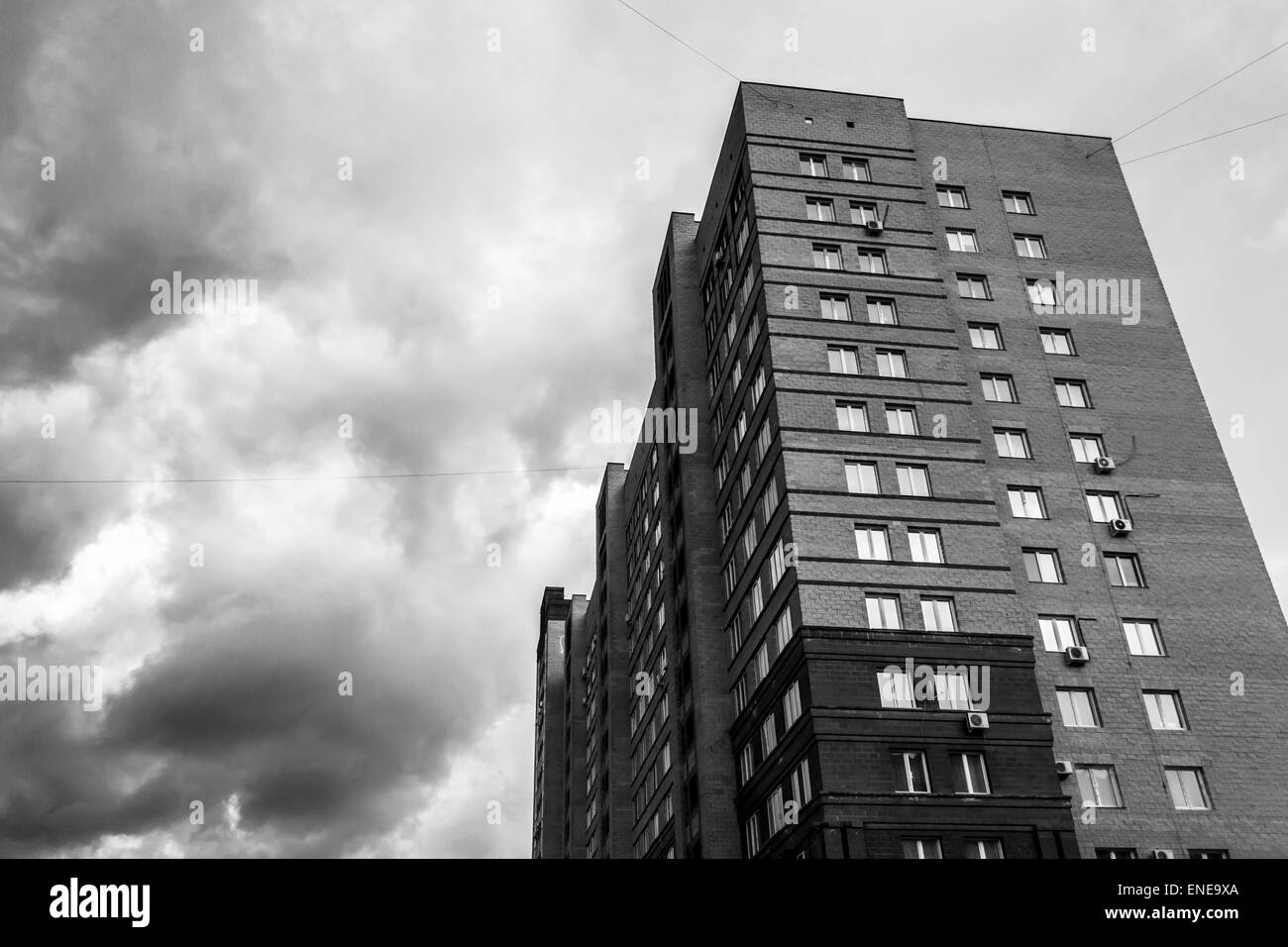 High rise tower block in back and white monochrome with dark storm ...