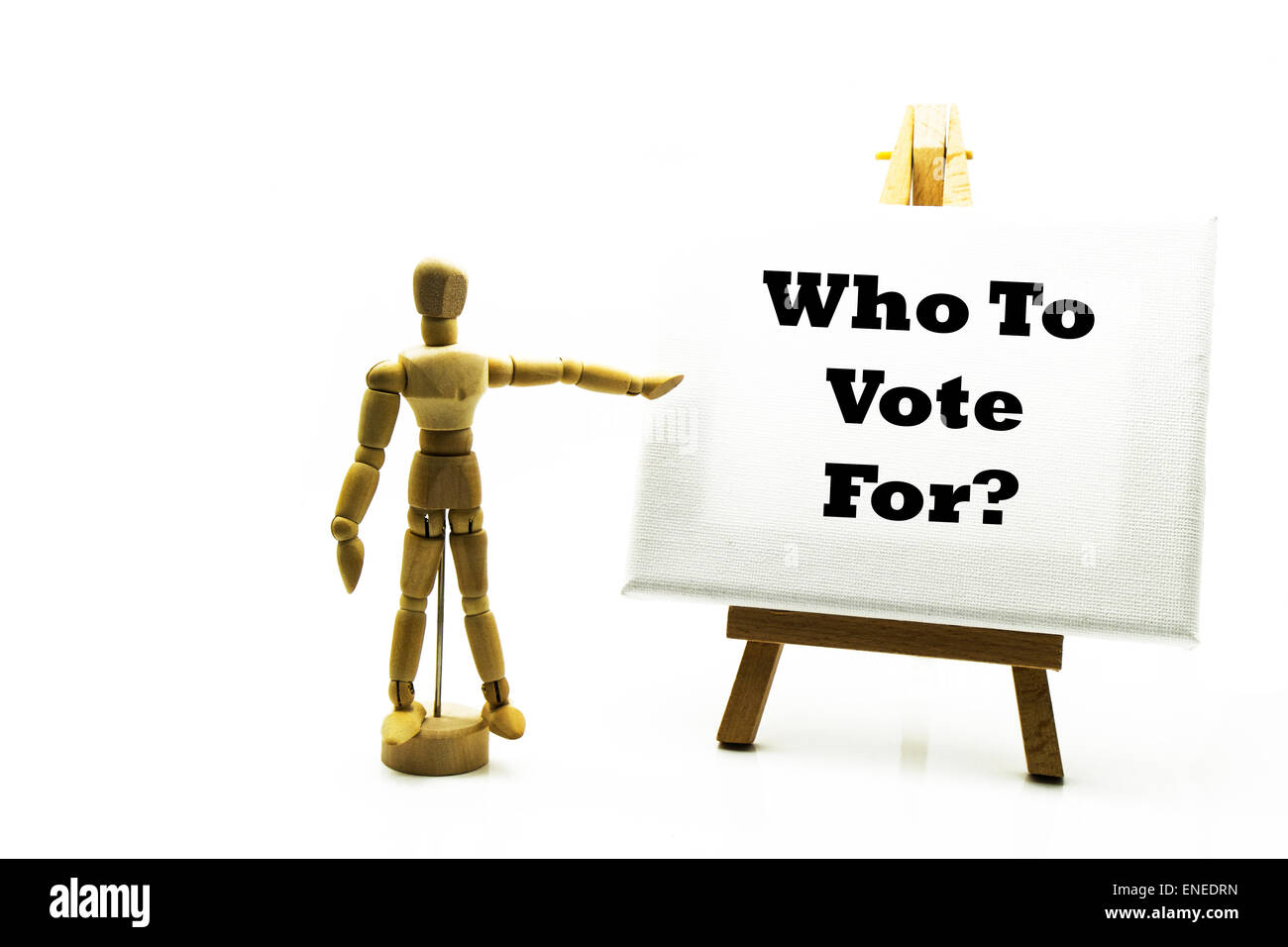Wooden man with white board pointing at words "who to vote for ...