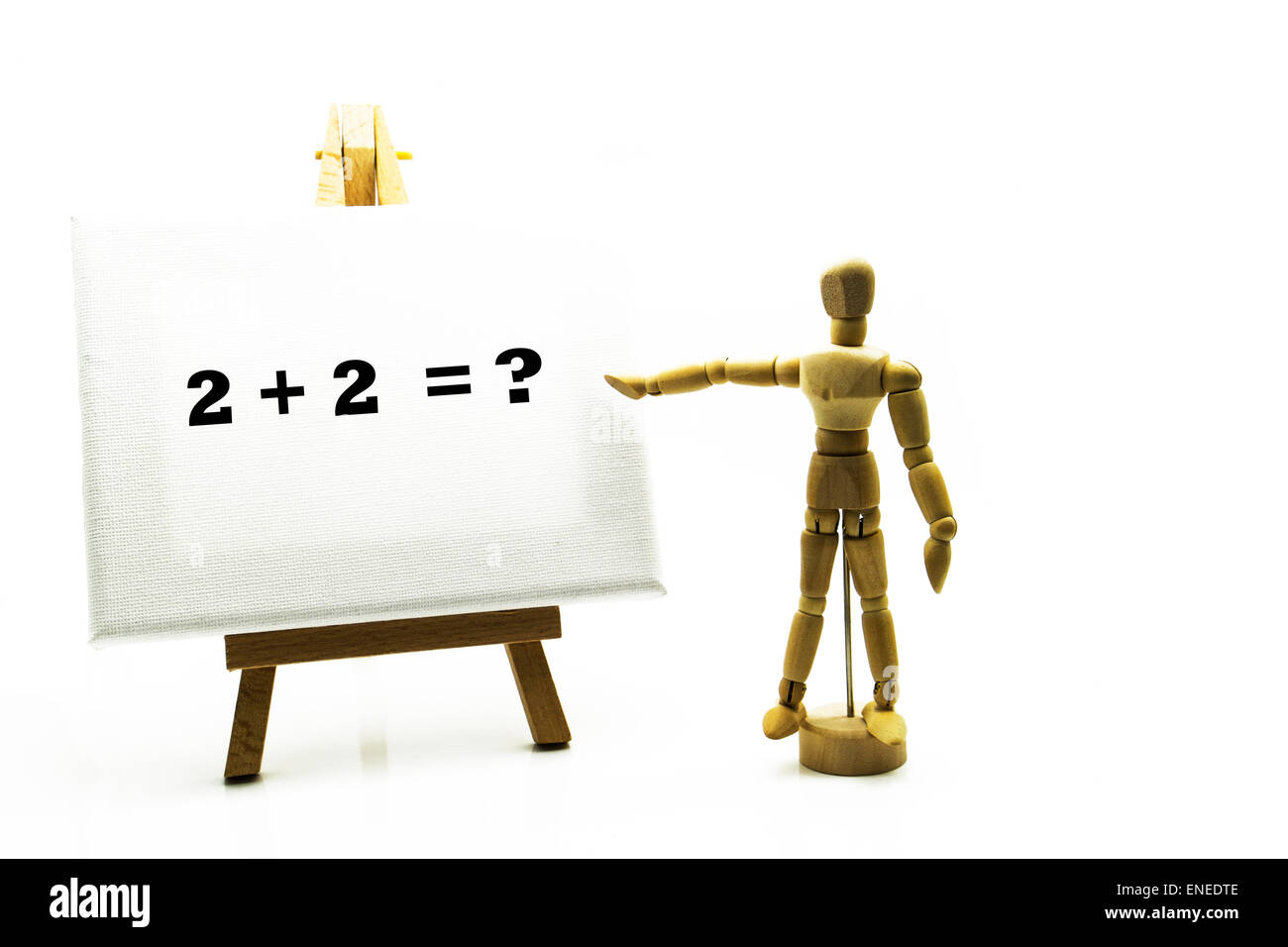 Wooden man with white board pointing at words "2 + 2 = ?" sum sums ...