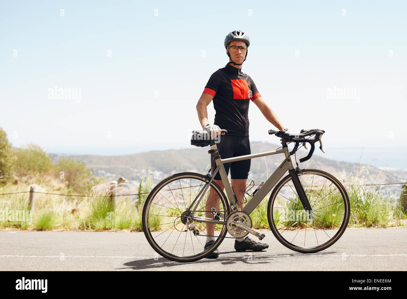 Young male cyclist standing with his bike while out for a ride in ...