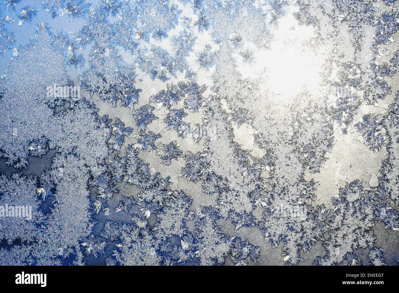 Frozen snowflakes and frost pattern over the sun on frozen Christmas ...