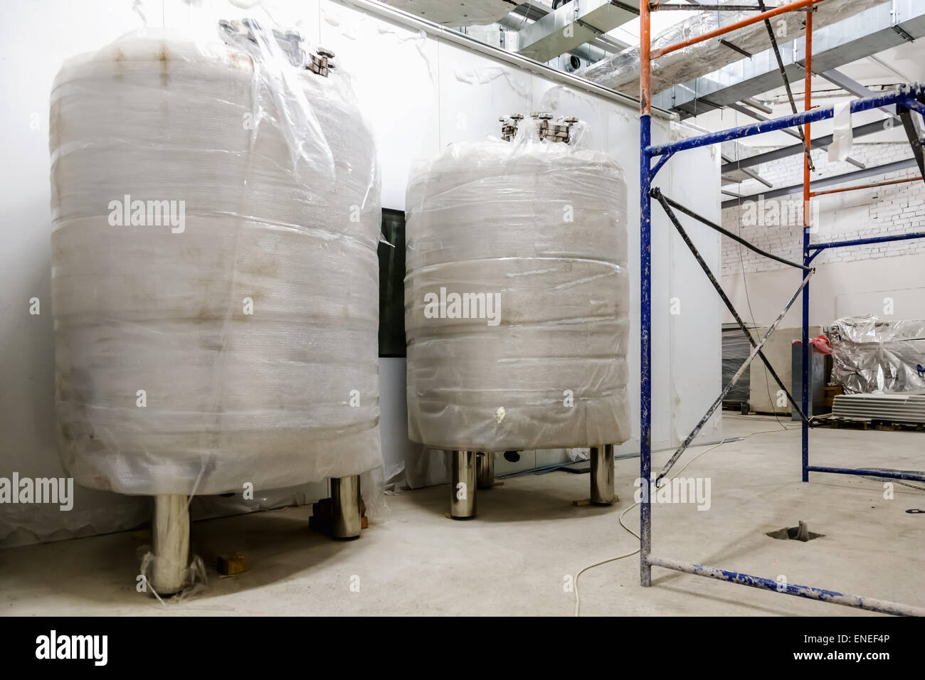 Interior of industrial building with big boiler or reservoir under ...