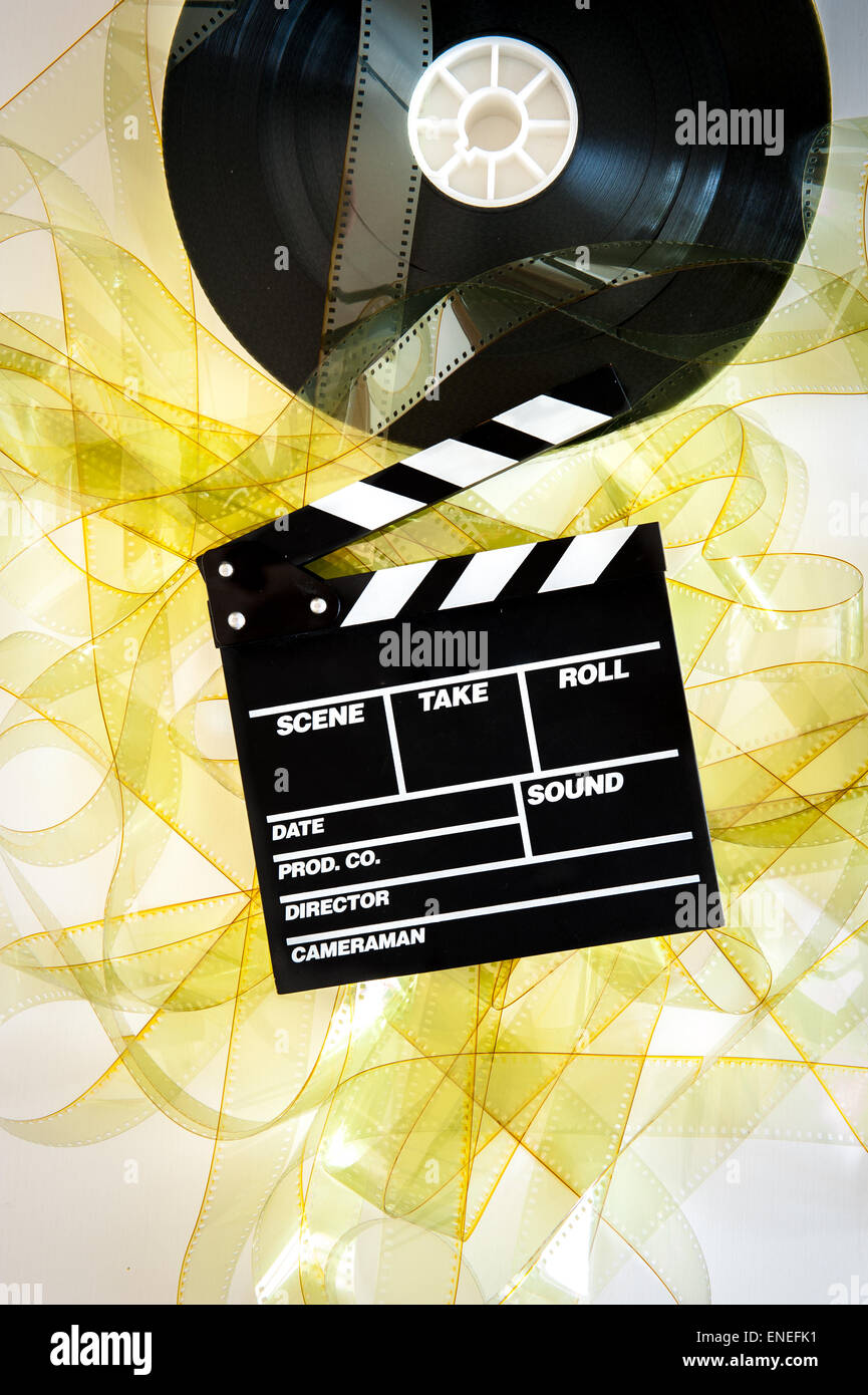 Movie clapper on 35 mm cinema reel unrolled yellow filmstrip on white ...