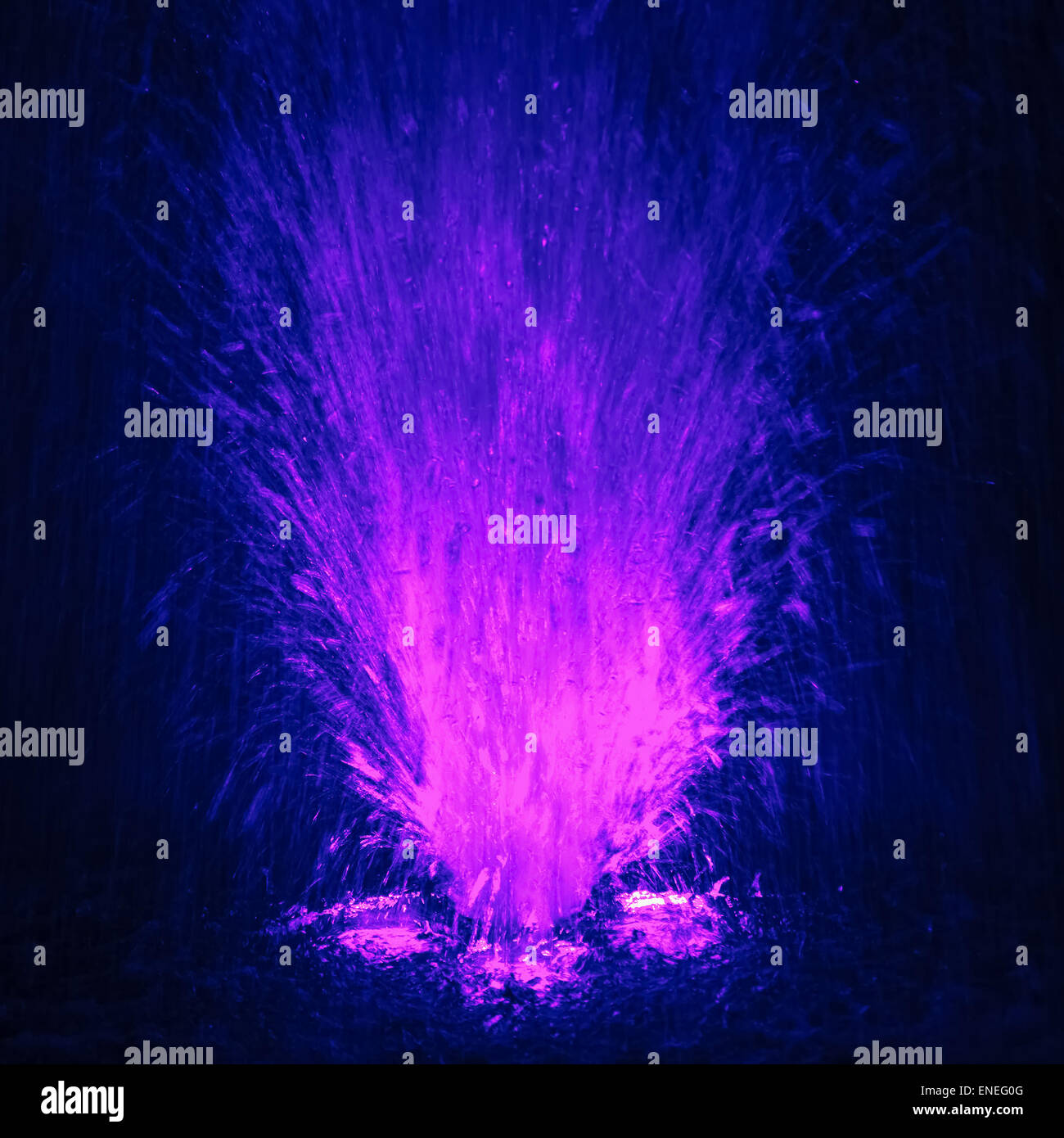 Colorful fountain splashes violet and blue color of water drops on a ...