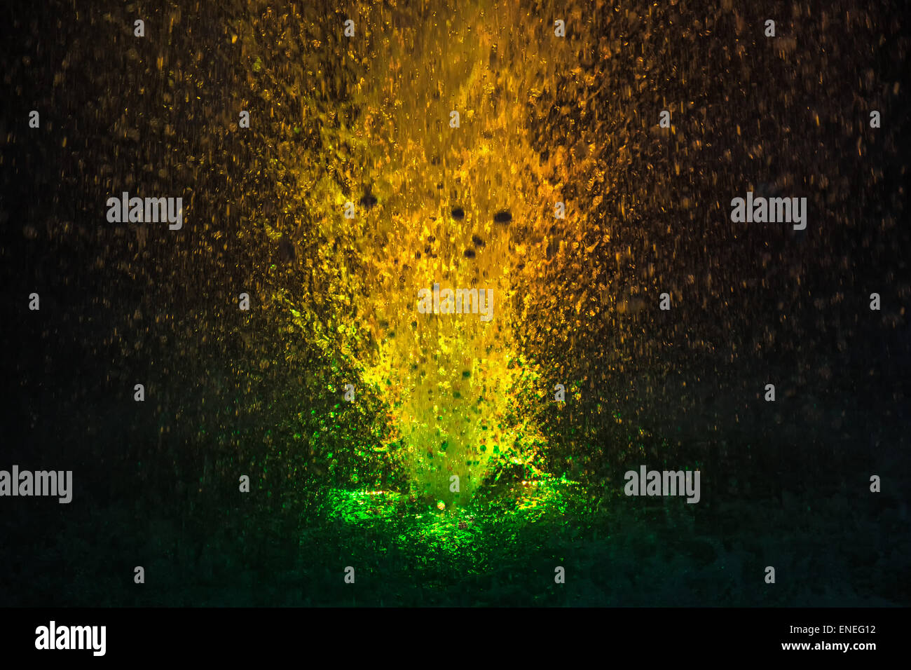 Colorful fountain splashes yellow and green color of water drops on a ...