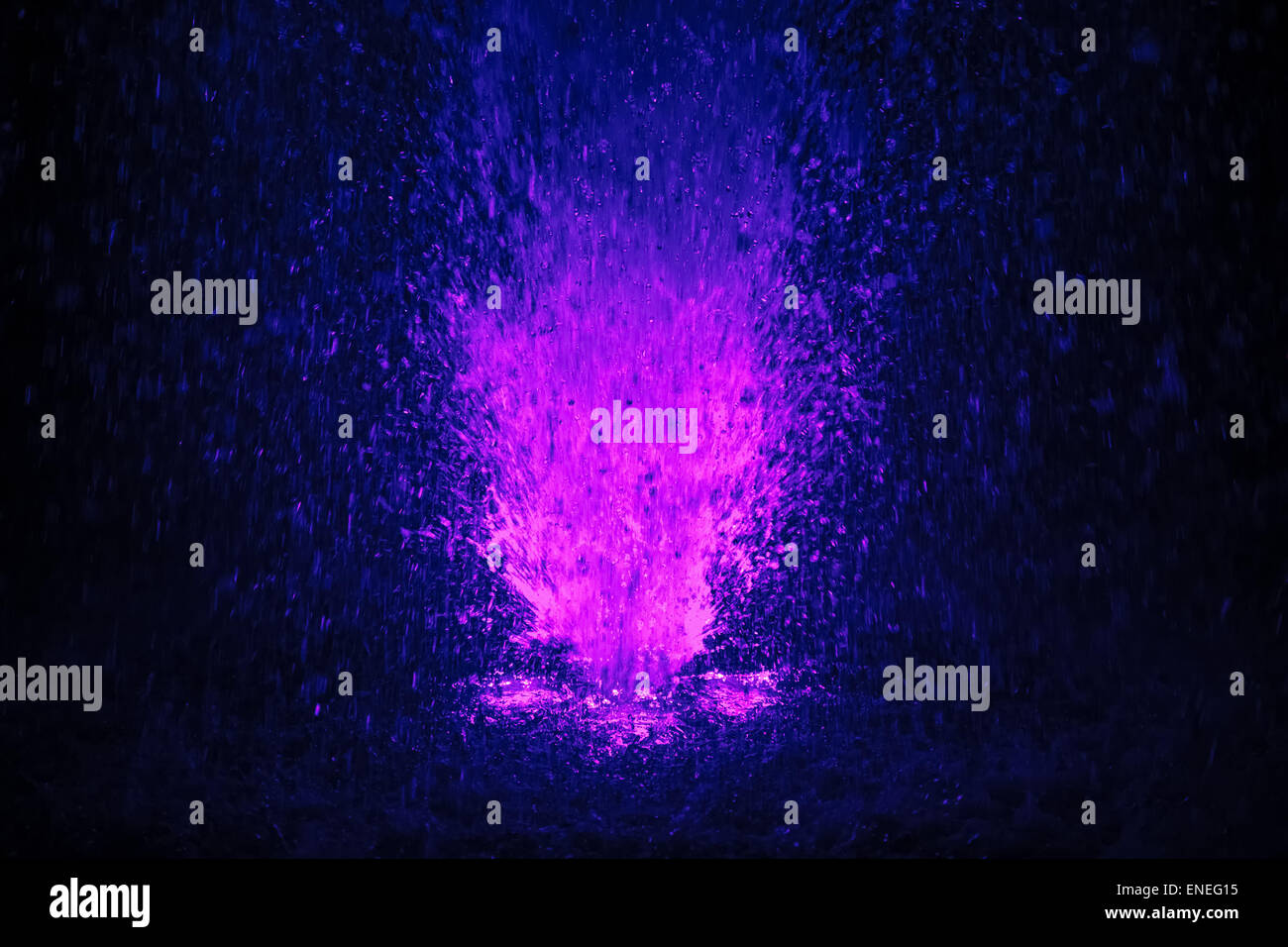 Colorful fountain splashes violet and blue color of water drops on a ...