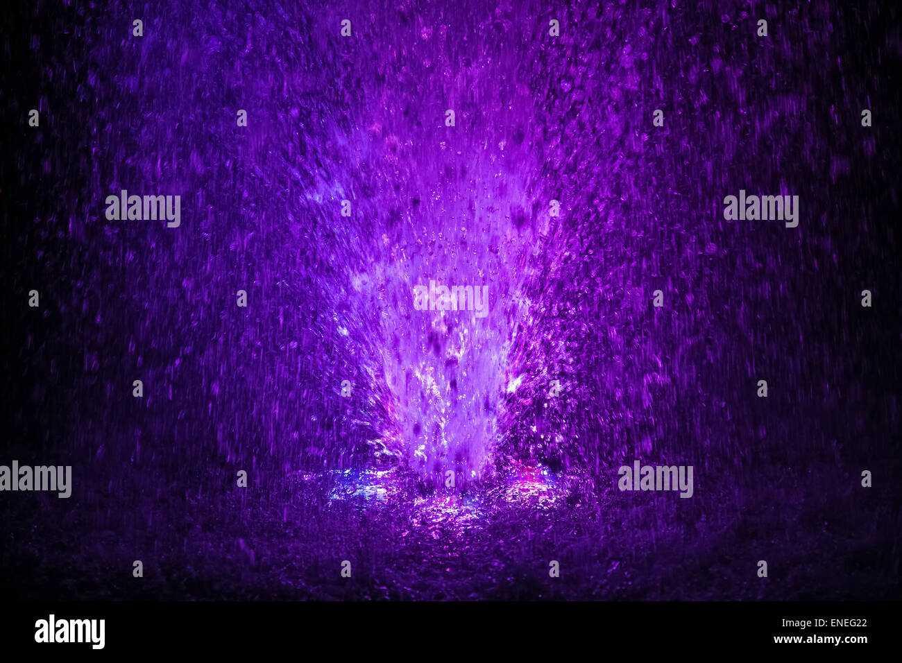 Colorful fountain splashes violet and white color of water drops on a ...