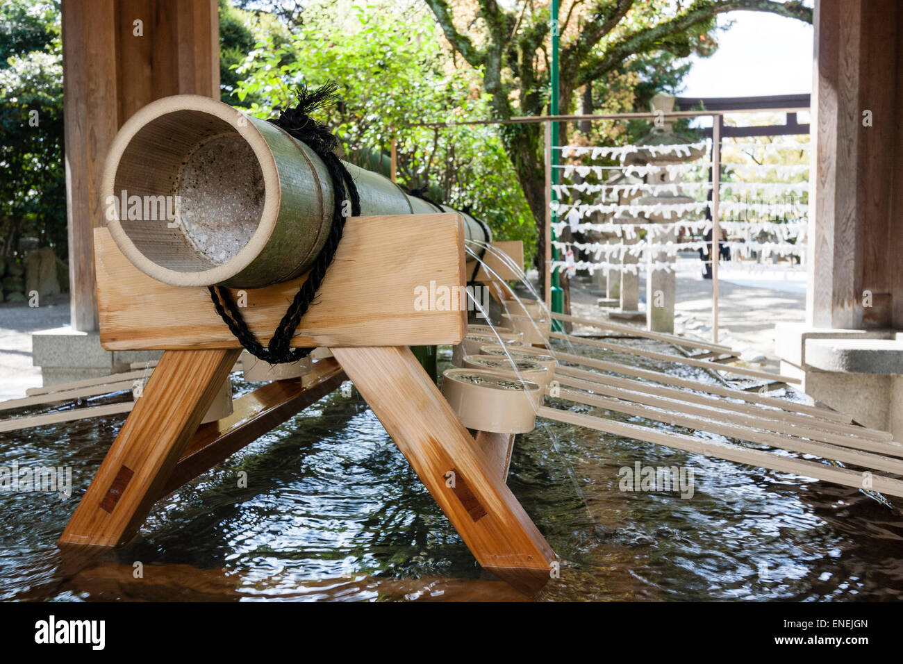 Close up ladles and the bamboo pipe on a trestle, with water pouring ...