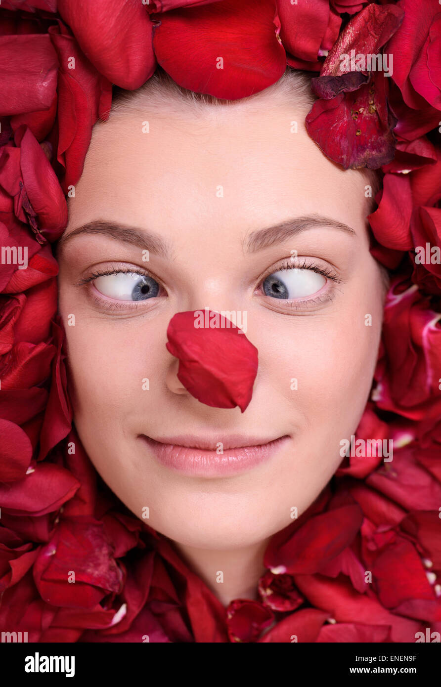 Funny woman in roses with petal on nose. Top view Stock Photo - Alamy